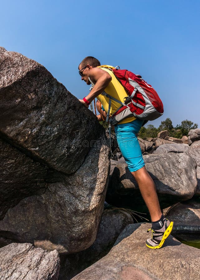 Hiker climbing on a rock stock photo. Image of backpacker - 66319634