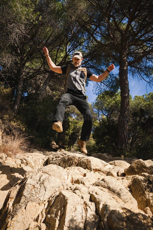 Hiker in a Forest Jumping on Rocks Stock Photo - Image of sport ...