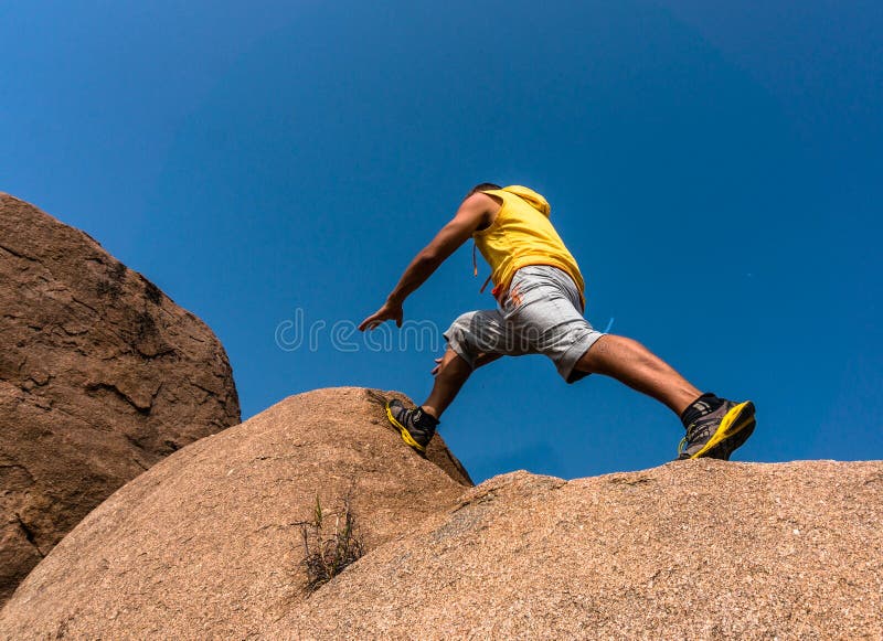 Hiker Jumping Over the Rock Stock Photo - Image of blue, lifestyle ...