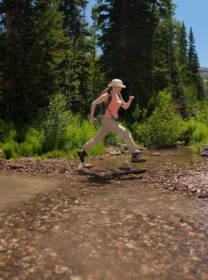 Hiker leaping over stream stock image. Image of creek - 10371903