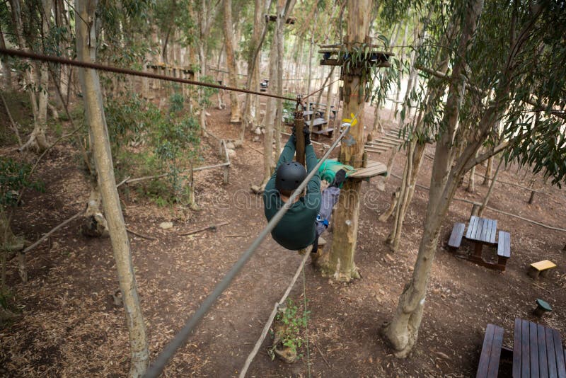 Hiker Man Going Down a Zip Line in the Forest Stock Photo - Image of ...