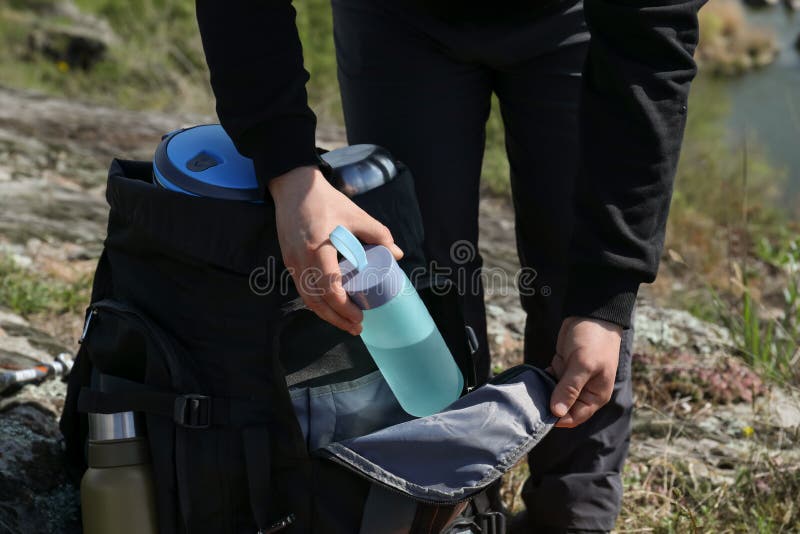 Hiker Putting Bottle of Water into Backpack Outdoors, Closeup Stock ...