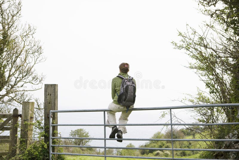 Hiker Sitting on Gate while Looking at View Stock Photo - Image of ...
