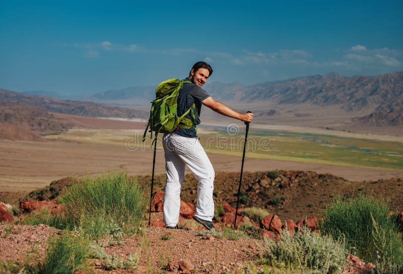 Hiker on the Top of Mountain with Backpack and Trekking Poles Turned ...
