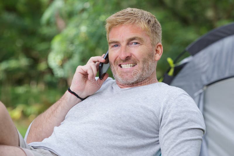 Hiker in woods using phone stock photo. Image of horizon - 261516356