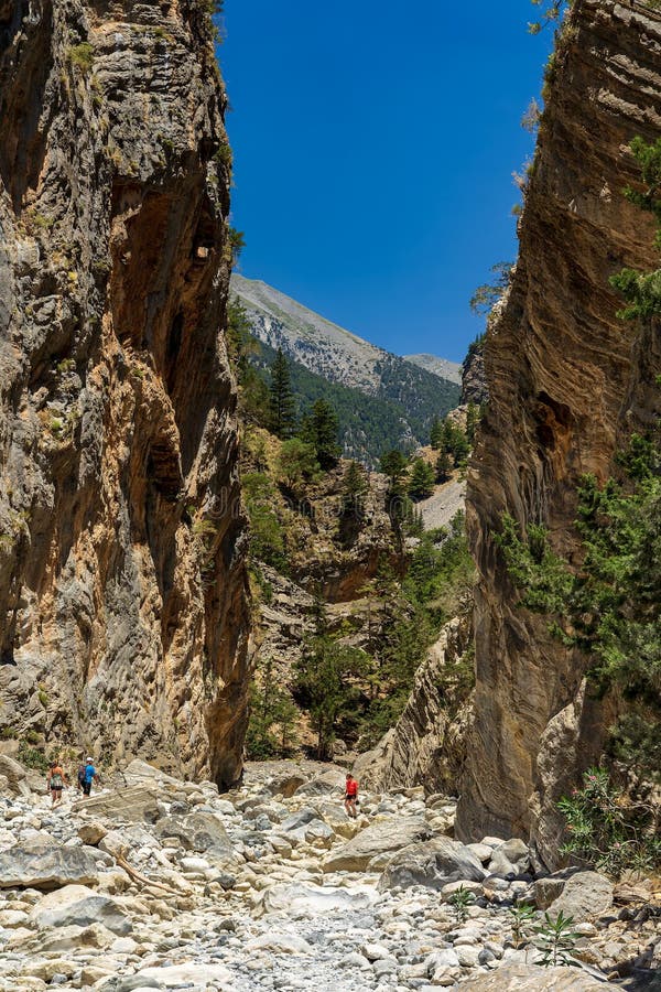Hikers in a Deep Gorge Surrounded by Spectacular Cliffs during a Hot ...