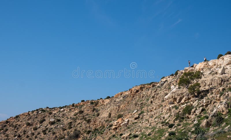 Hikers Exploring Rocky Mountain Ridge Under Clear Blue Sky Stock Image ...