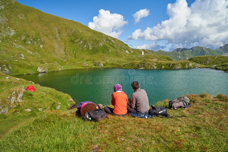 Hikers resting by a lake stock image. Image of healthy - 194406321