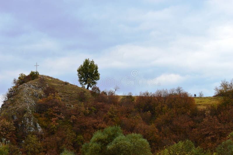 Hill, a tree and a cross stock photo. Image of people - 129860394