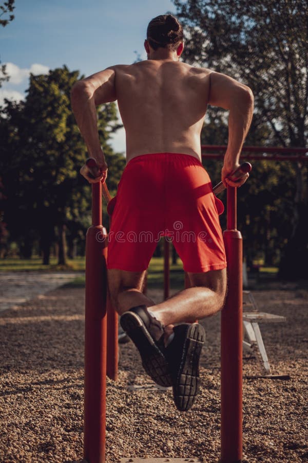 Hipster Doing Dips on the Bars in the Outdoor Gym Stock Photo - Image ...