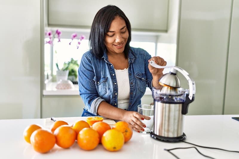Hispanic Brunette Woman Preparing Orange Juice at the Kitchen Stock ...