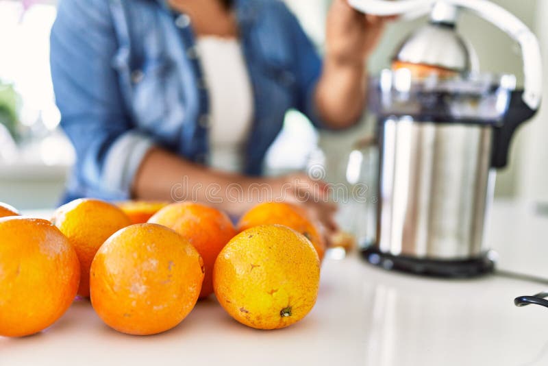 Hispanic Brunette Woman Preparing Orange Juice at the Kitchen Stock ...