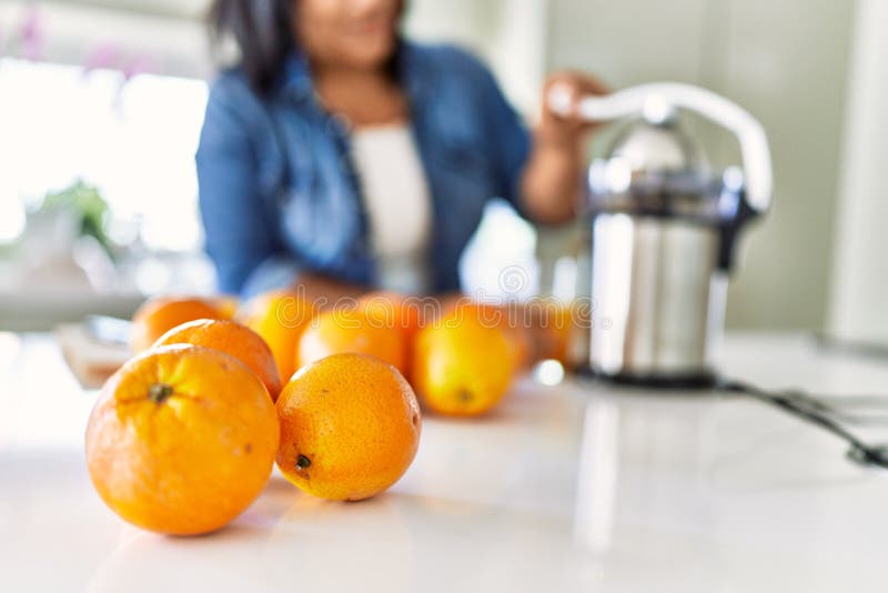 Hispanic Brunette Woman Preparing Orange Juice at the Kitchen Stock ...