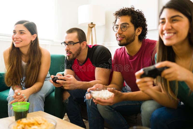 Hispanic Couples Hanging Out and Playing Video Games with Snacks Stock ...