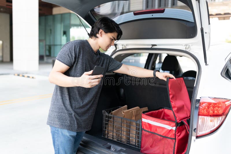 Young Delivery Man Opening Backpack in Car Stock Image - Image of ...