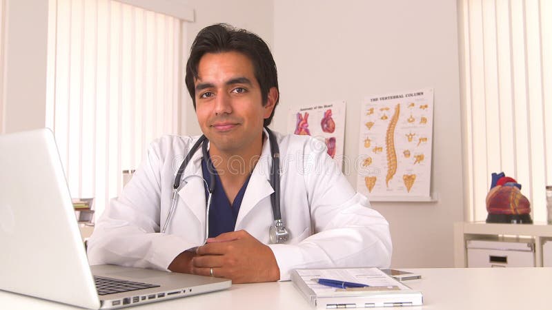 Hispanic Doctor Sitting at Desk in Office Stock Footage - Video of ...
