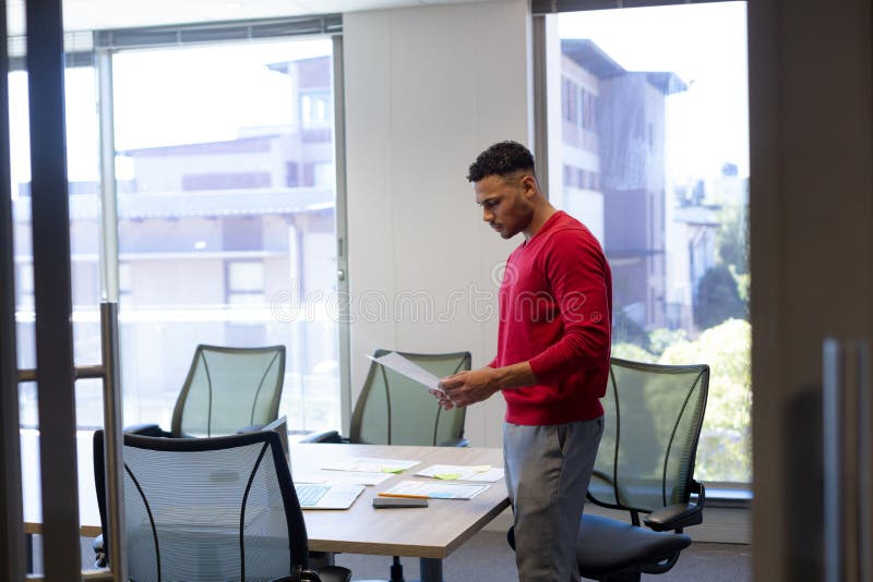 Hispanic Male Advisor Analyzing Document at Conference Table in ...