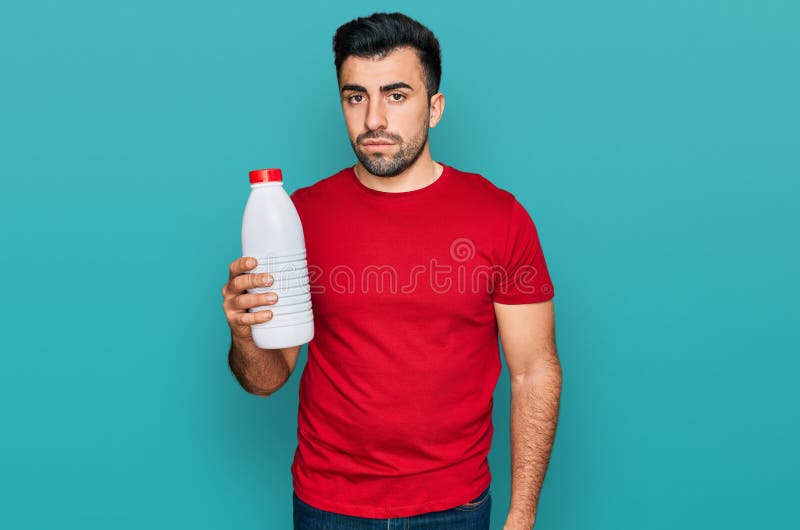 Hispanic Man with Beard Holding Liter Bottle of Milk Thinking Attitude ...
