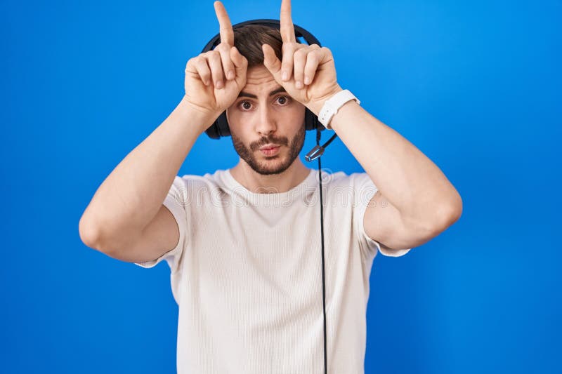 Hispanic Man With Beard Listening To Music Wearing Headphones Doing