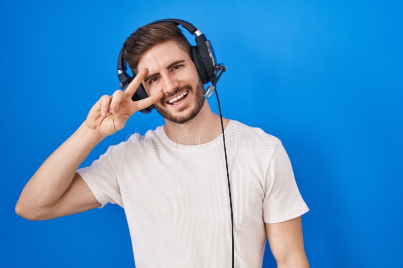 Hispanic Man With Beard Listening To Music Wearing Headphones Doing