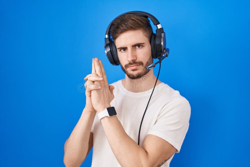Hispanic Man With Beard Listening To Music Wearing Headphones Holding