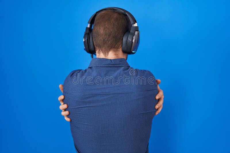 Hispanic Man With Beard Listening To Music Wearing Headphones Hugging
