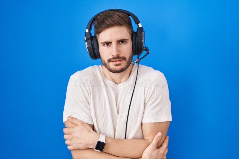 Hispanic Man With Beard Listening To Music Wearing Headphones Shaking