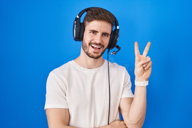 Hispanic Man With Beard Listening To Music Wearing Headphones Smiling
