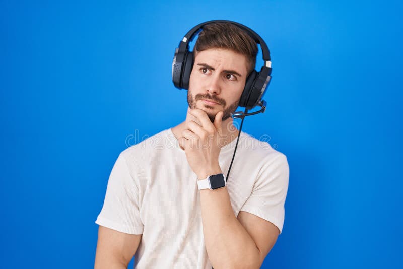 Hispanic Man With Beard Listening To Music Wearing Headphones Thinking