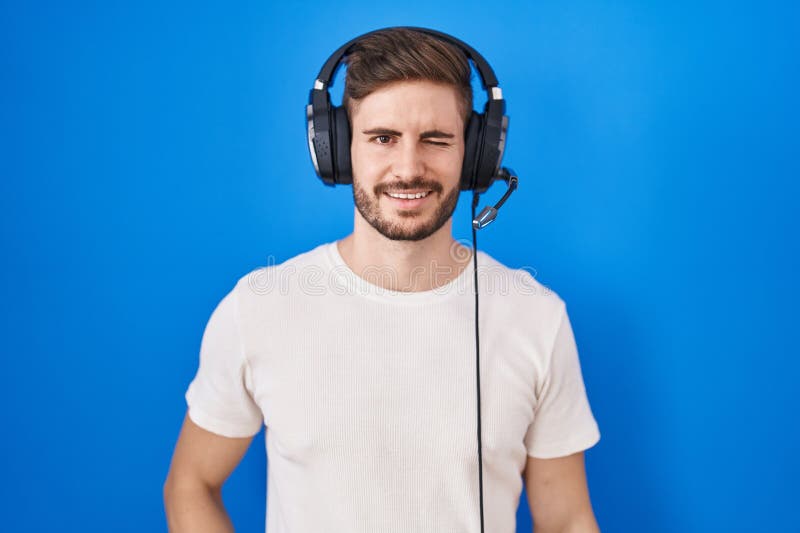 Hispanic Man With Beard Listening To Music Wearing Headphones Winking