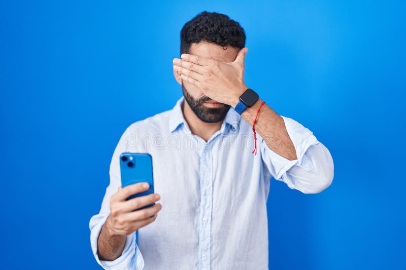 Hispanic Man with Beard Using Smartphone Typing Message Covering Eyes ...