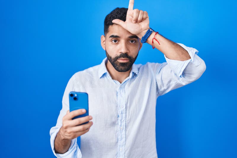 Hispanic Man With Beard Using Smartphone Typing Message Making Fun Of