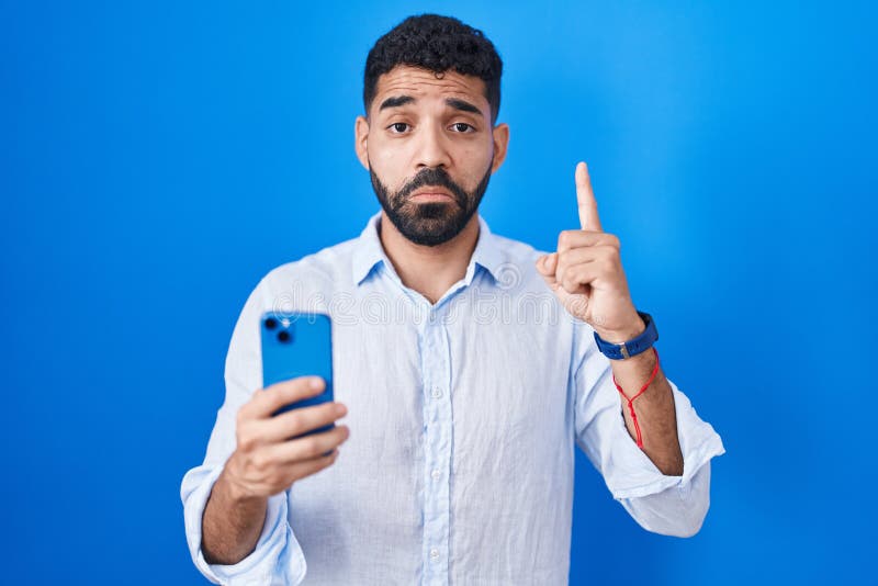 Hispanic Man With Beard Using Smartphone Typing Message Pointing Up
