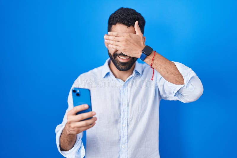 Hispanic Man With Beard Using Smartphone Typing Message Smiling And