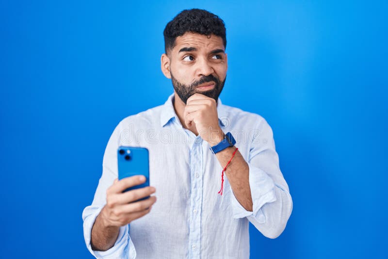 Hispanic Man With Beard Using Smartphone Typing Message Thinking