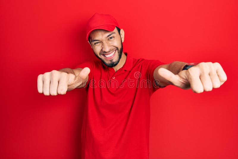 Hispanic Man With Beard Wearing Delivery Uniform And Cap Approving