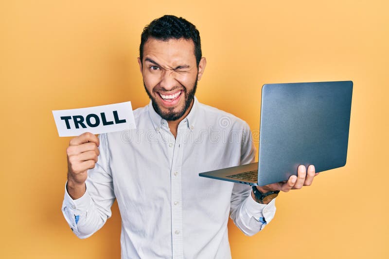 Hispanic Man with Beard Working Using Computer Laptop Holding Banner ...