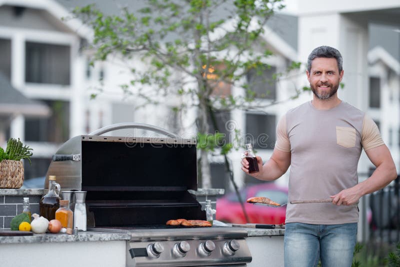 Hispanic Man Cooking on Barbecue in the Backyard. Chef Preparing ...