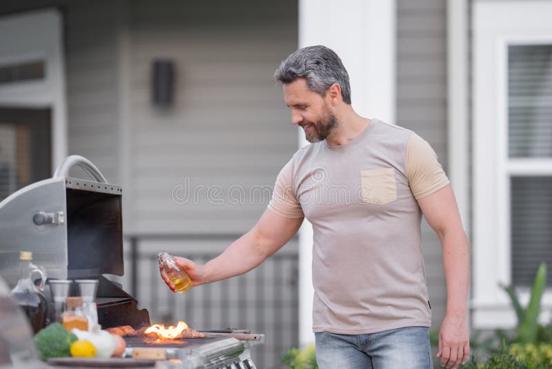 Hispanic Man Cooking on Barbecue in the Backyard. Chef Preparing ...