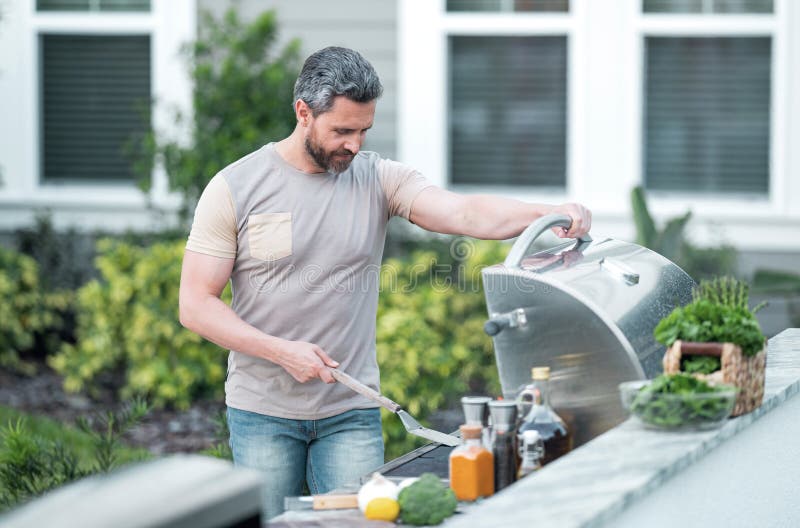 Hispanic Man Cooking on Barbecue in the Backyard. Chef Preparing ...