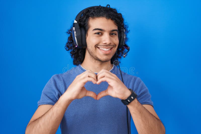 Hispanic Man with Curly Hair Listening To Music Using Headphones ... Hispanic Man with Curly Hair Listening To Music Using Headphones ...