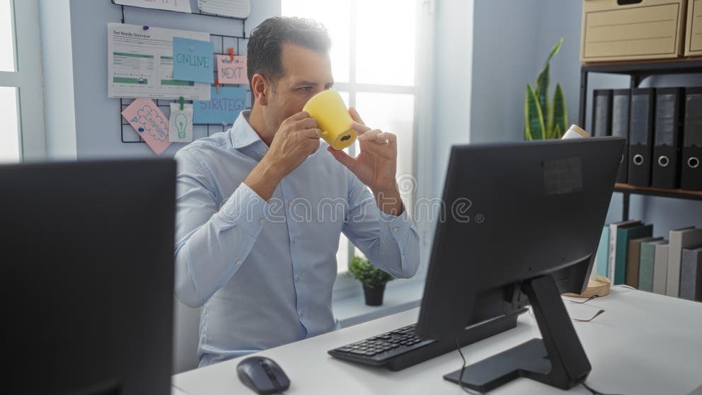 Hispanic Man Drinking Coffee, Working in a Modern Office with Computers ...