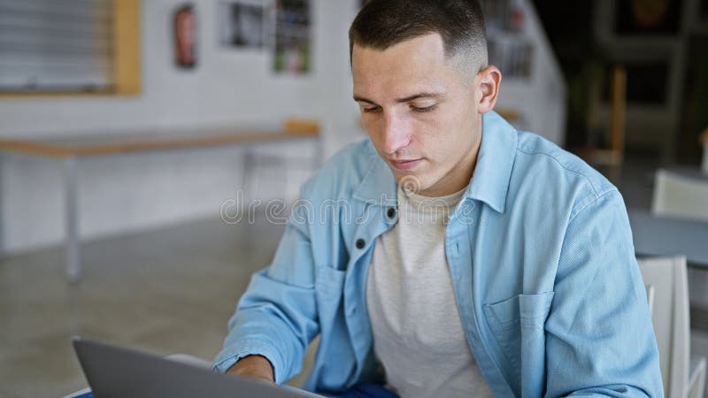 Hispanic Man Focused on Studying with Laptop in a Modern University ...
