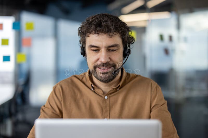 Hispanic Man with Headset Working on Laptop in Office Stock Photo ...