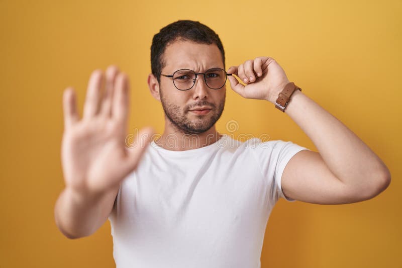 Hispanic Man Holding Glasses with Open Hand Doing Stop Sign with ...