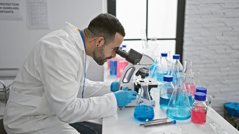 Man in a Lab Coat Using a Microscope To Examine a Sample, Suitable for ...