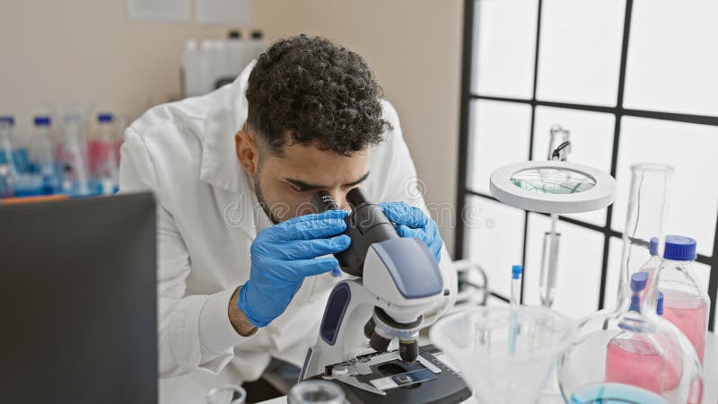 Man in a Lab Coat Using a Microscope To Examine a Sample, Suitable for ...