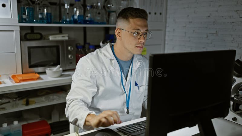 Hispanic Man in Lab Coat Working at Computer in Scientific Laboratory ...