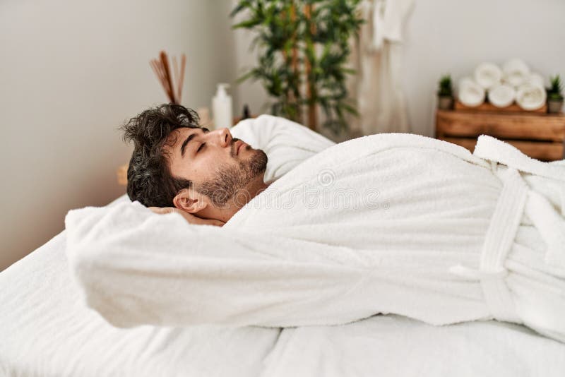 Hispanic Man Relaxed with Hands on Head Lying on the Table at Beauty ...