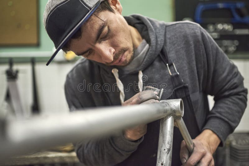 Hispanic Man Sanding a Bicycle Frame at His Workshop Stock Photo ...
